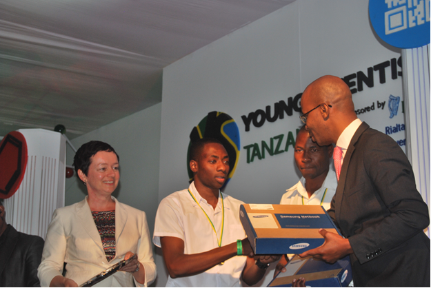Hon January Makamba presents a prize to the over all winner of 2013 ...