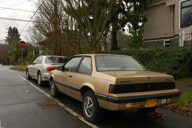 OLD PARKED CARS.: 1985 Pontiac Sunbird SE Turbo.