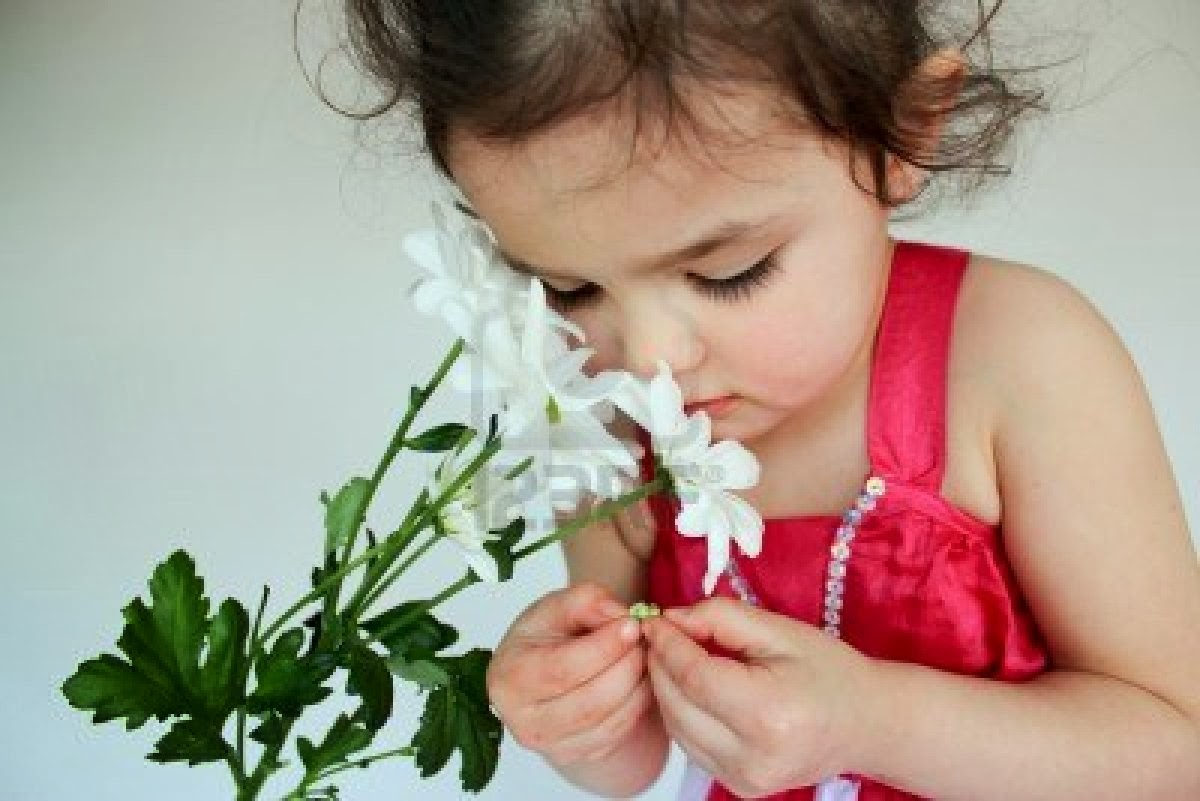Una persona oliendo una flor - Imagui