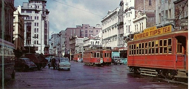 transpress nz: red Auckland trams in Queen Street, early 1950s