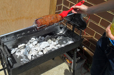 Outdoor cooking with charcoal: Spit roasted meat