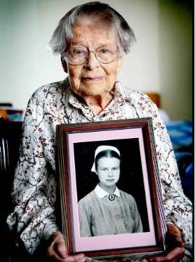 Erna Flegel com 93 anos, segurando sua foto de 1943, com seus 24 anos ...