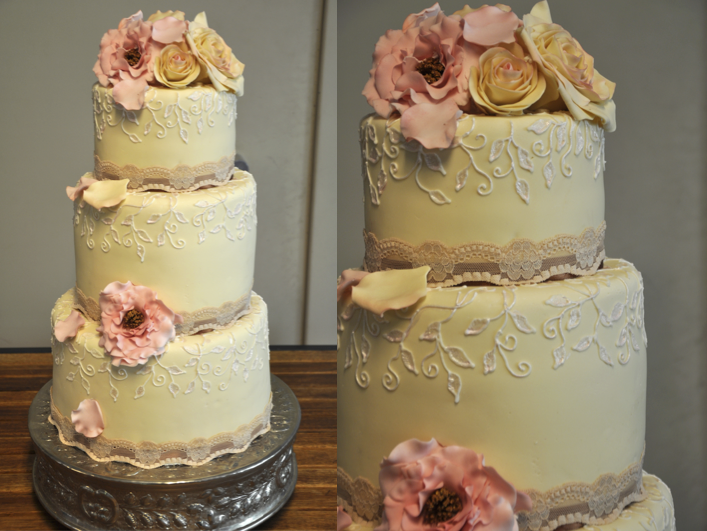 Beige wedding cake with pink roses and white leaf lace