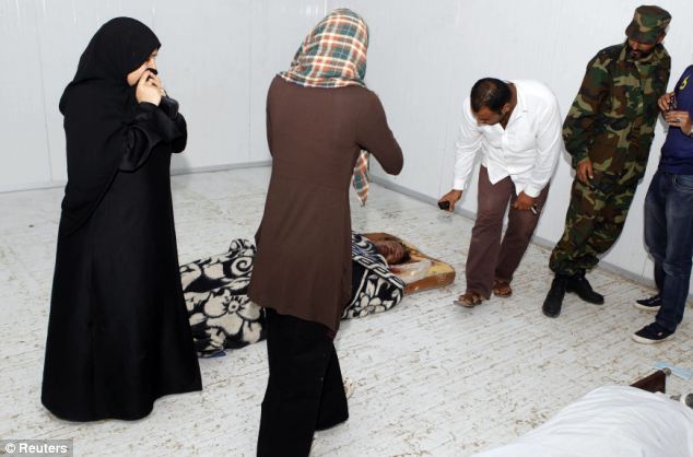 Ghoulish scenes as hundreds queue to gawp at Gaddafi's body as it lies ...