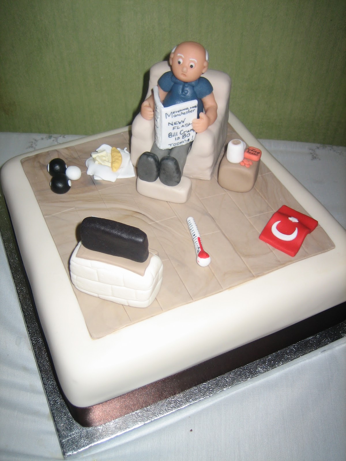 Sarah T Cakes: Novelty man sat in chair.