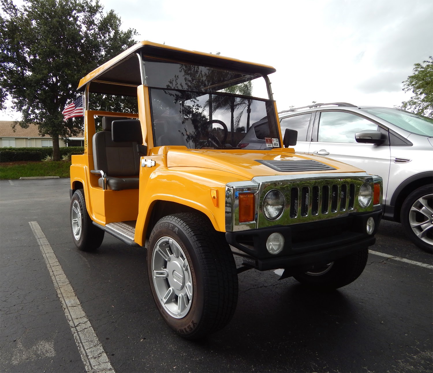 Yellow H3 Hummer Golf Cart says 'Bee Happy' in Sun City Center, Florida