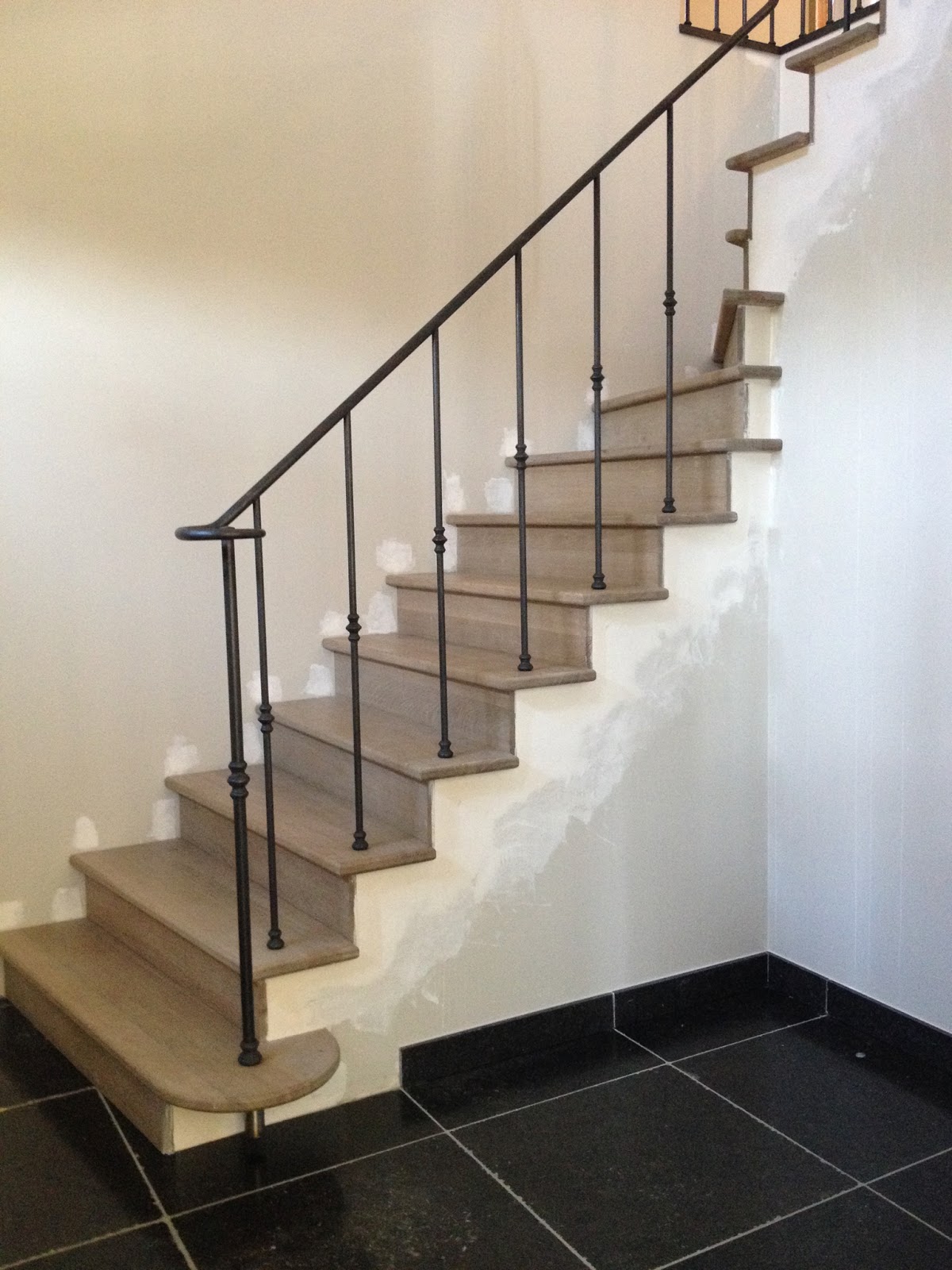 Trapleuning met ronde spijlen en gesmede krul | Van Dinter Metaalvormgeving