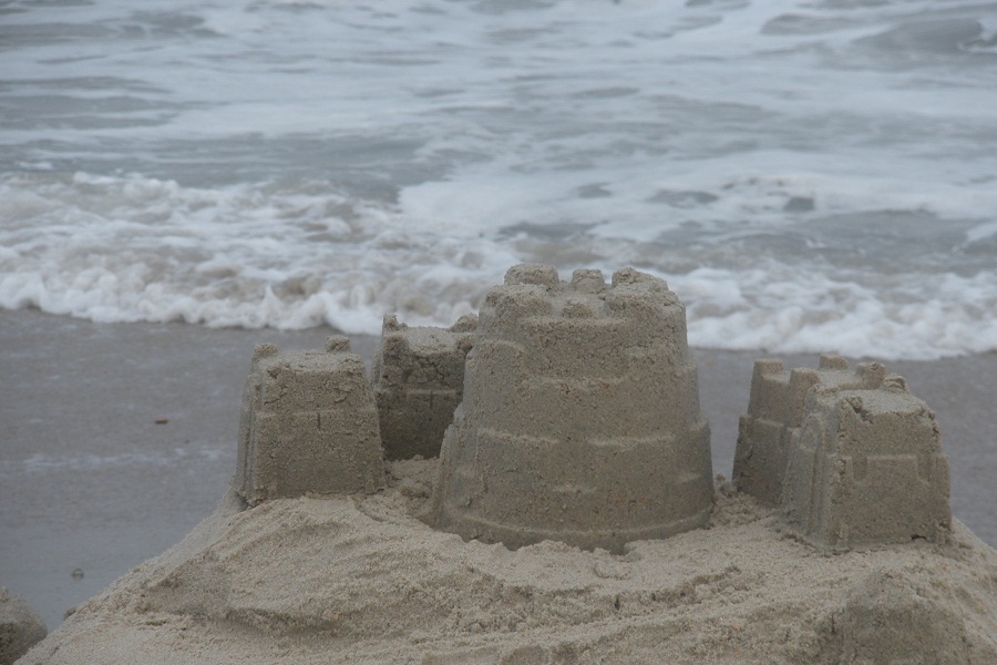 Why does damp sand hold the shape of a castle-shaped bucket on the ...