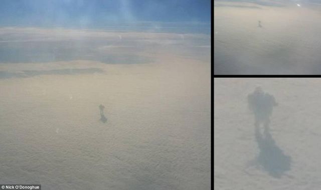 Mysterious shadow figure walking on clouds captured by plane passenger