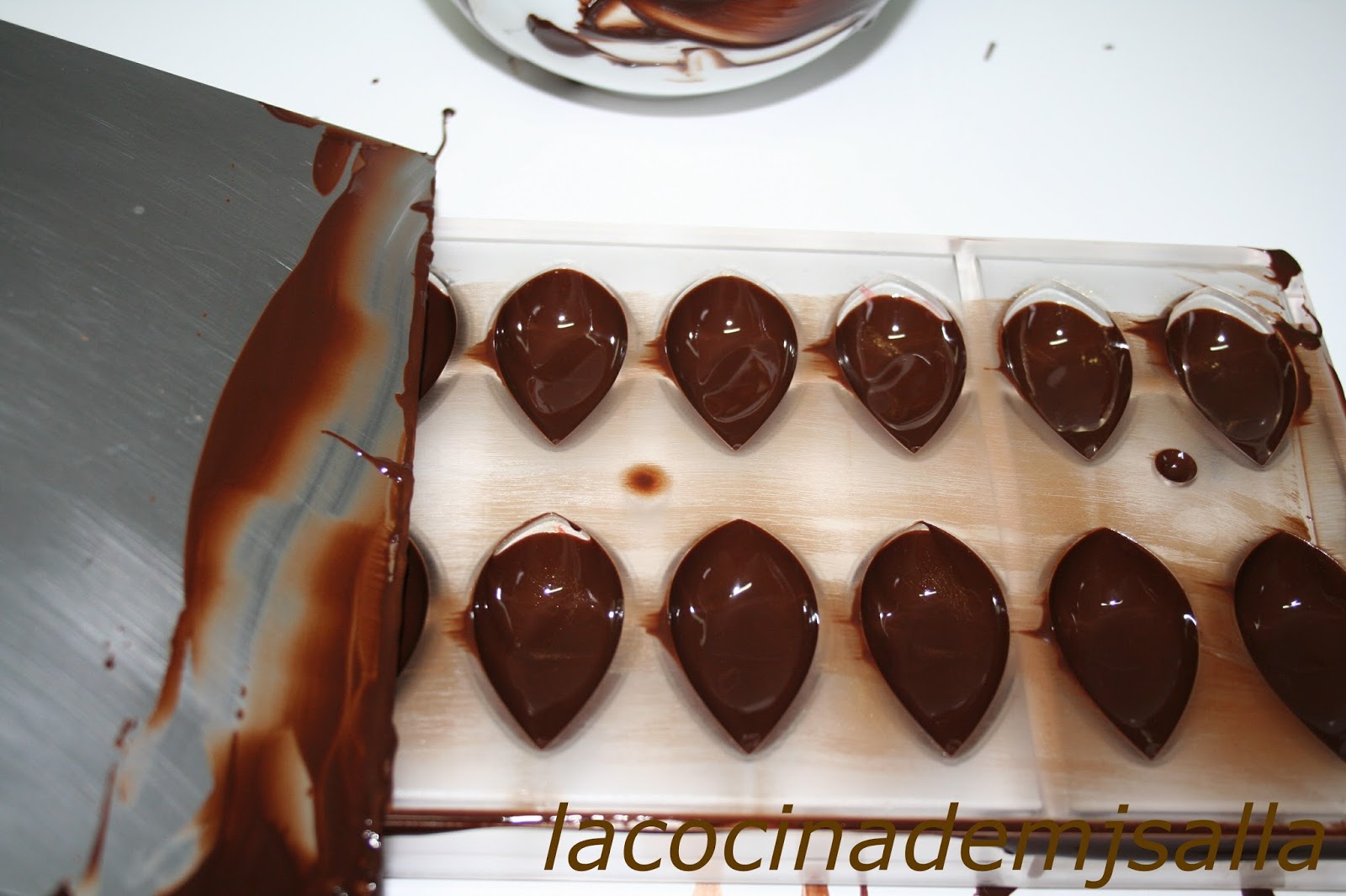 BOMBONES DECORADOS CON ORO Y ROJO BRILLANTES Y RELLENOS DE MOUSSE DE MANGO.