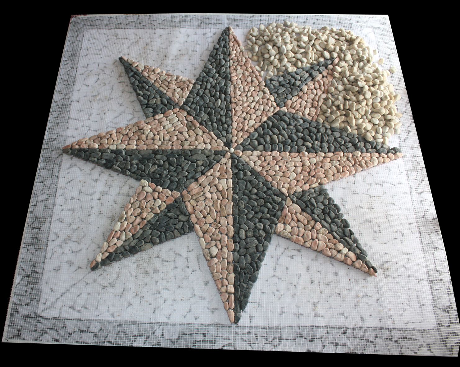 Un pezzo alla volta: Rosa dei venti a mosaico, sassi di marmo su rete