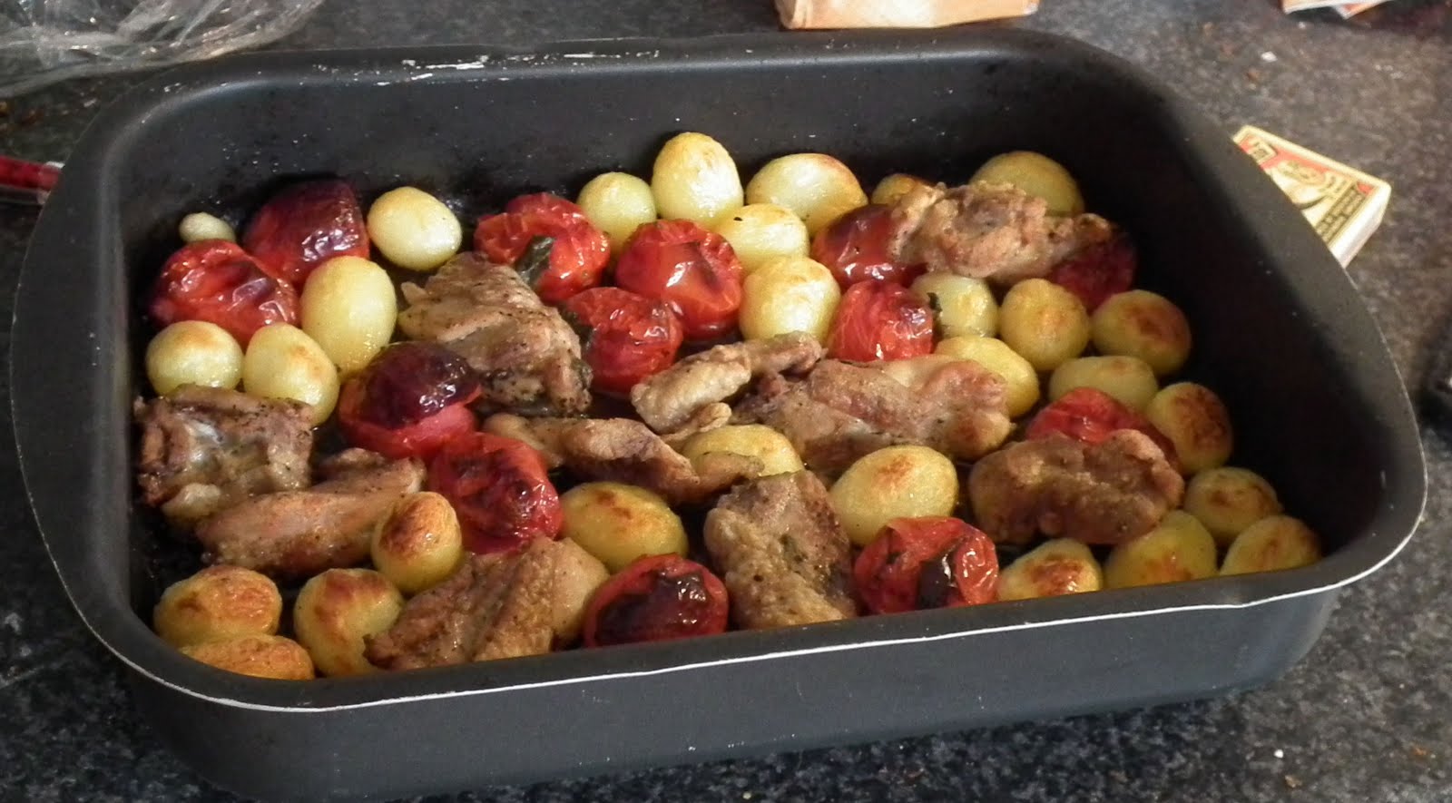 Kleverige kippendijen met aardappels en tomaten