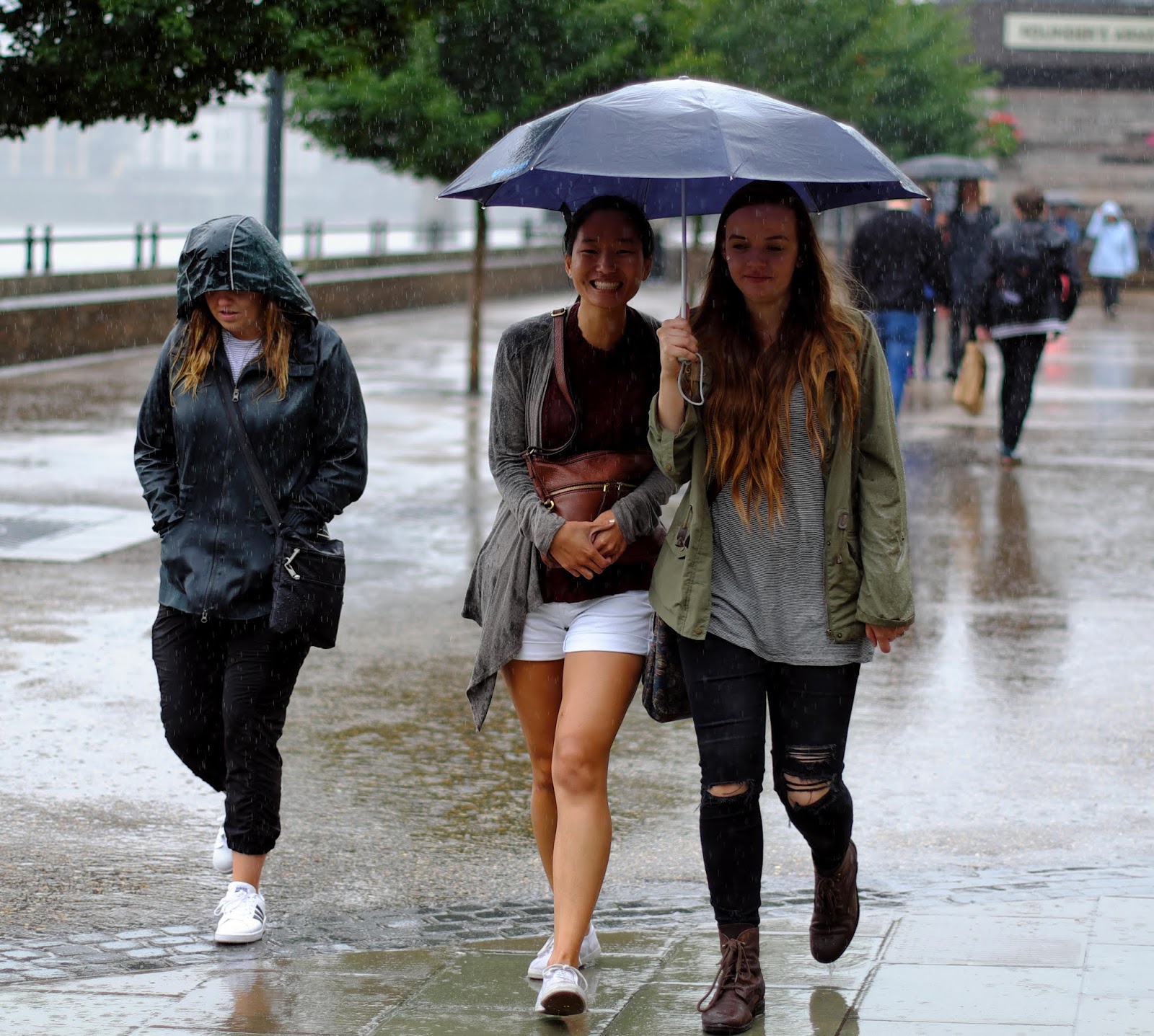 People Sharing An Umbrella