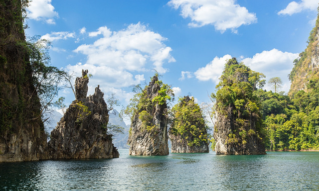 Epic limestone cliffs rising from crystal clear water, Khao Sok ...