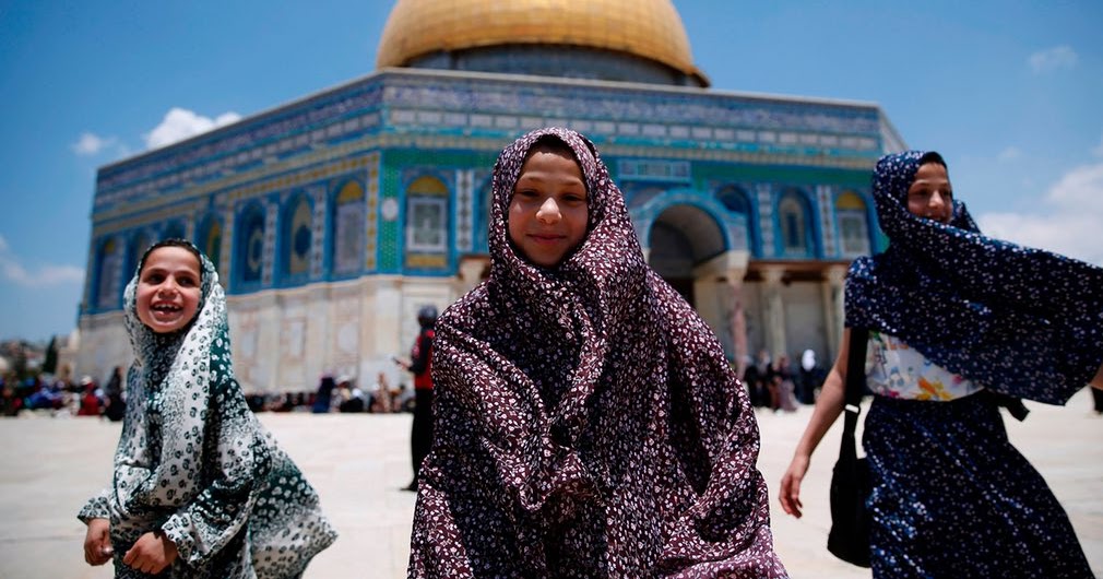 Palestinian children stand in front the Dome of the Rock
