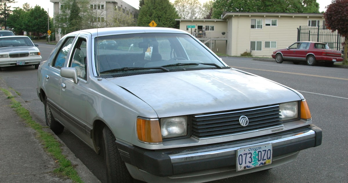 OLD PARKED CARS.: 1984 Mercury Topaz GS.