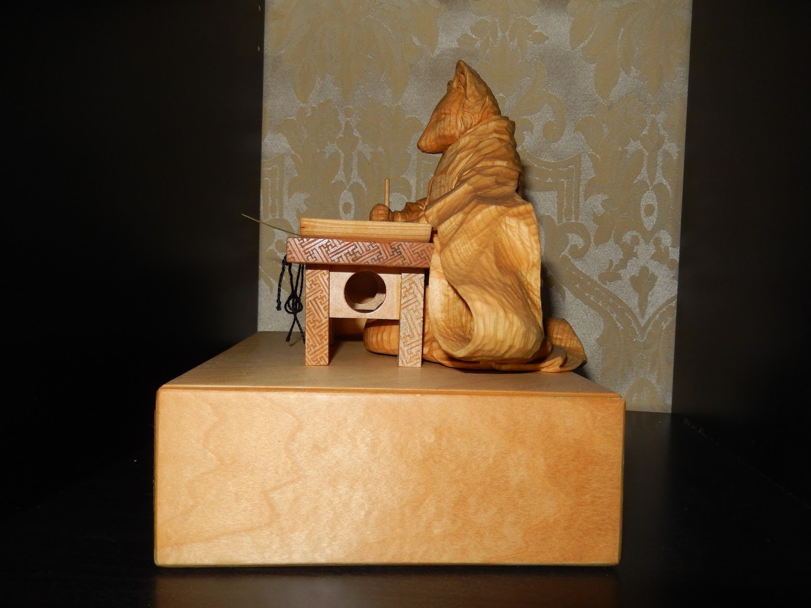 Woodcarving by Hannah Woodward: Fox 1 (The fox practices calligraphy.)