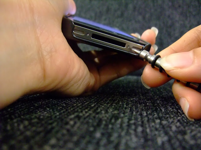 Using the attached screwdriver to remove the original screw.