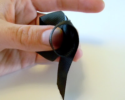 Now, holding your index finger on the point of the body, wrap the “head ...